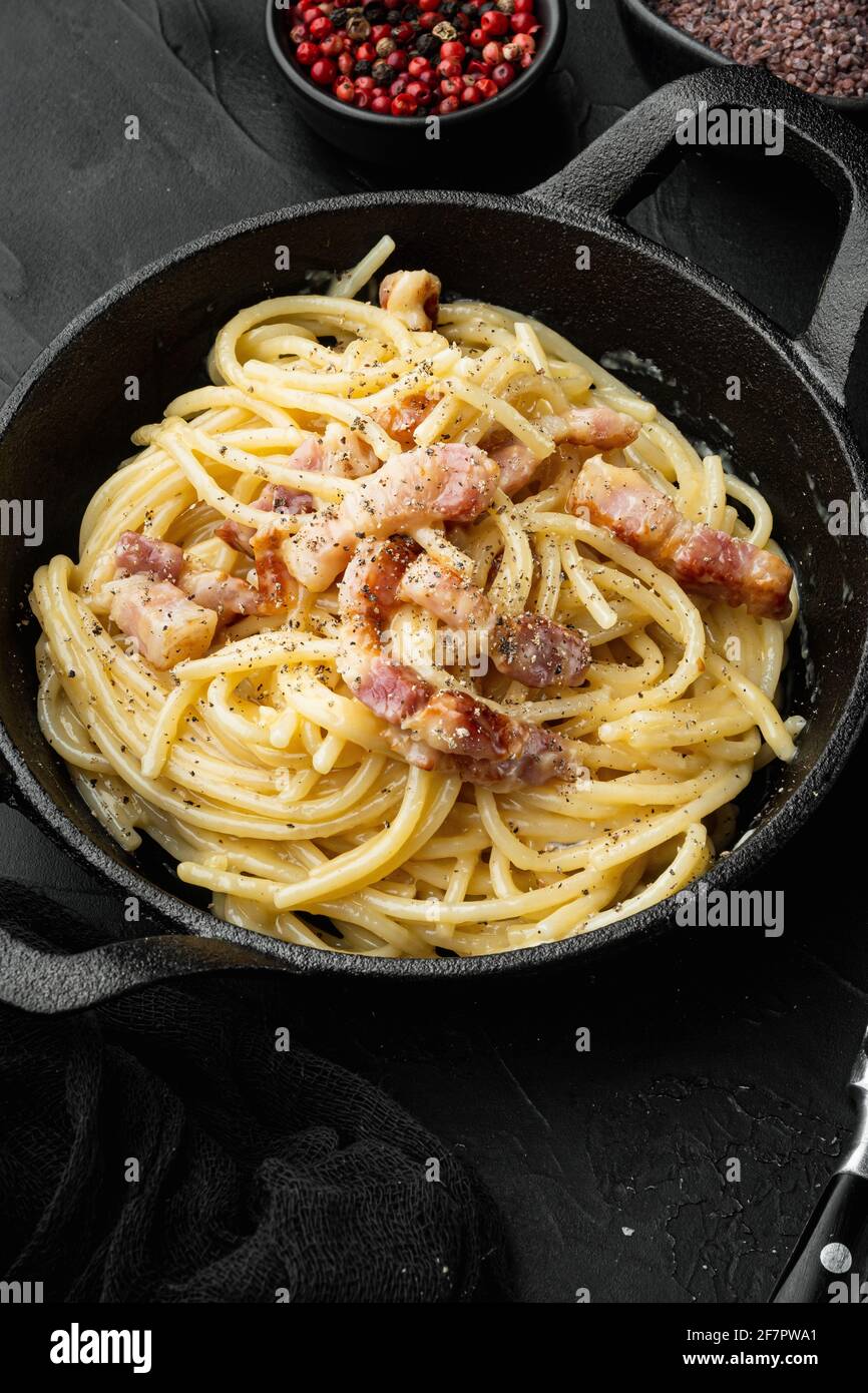 Homemade Carbonara pasta set, in cast iron frying pan, on black stone ...