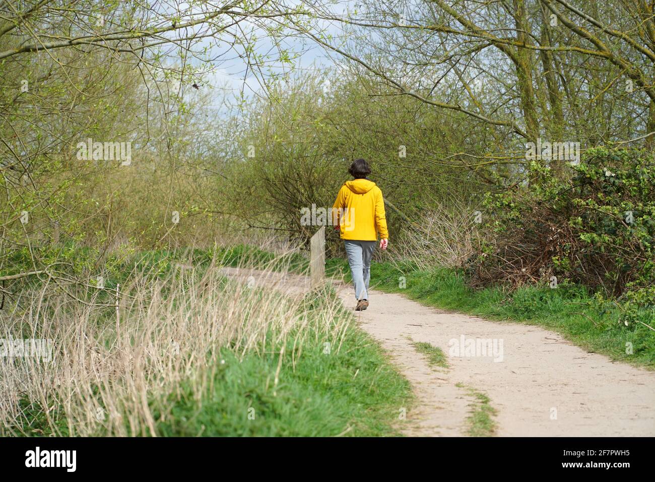 Young man in a yellow jacket walking away Stock Photo - Alamy