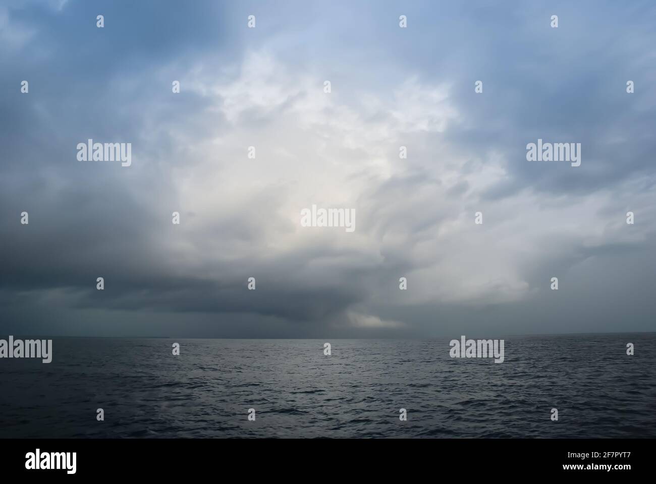 Massive rain clouds over a sea with a clear view of the horizon Stock ...