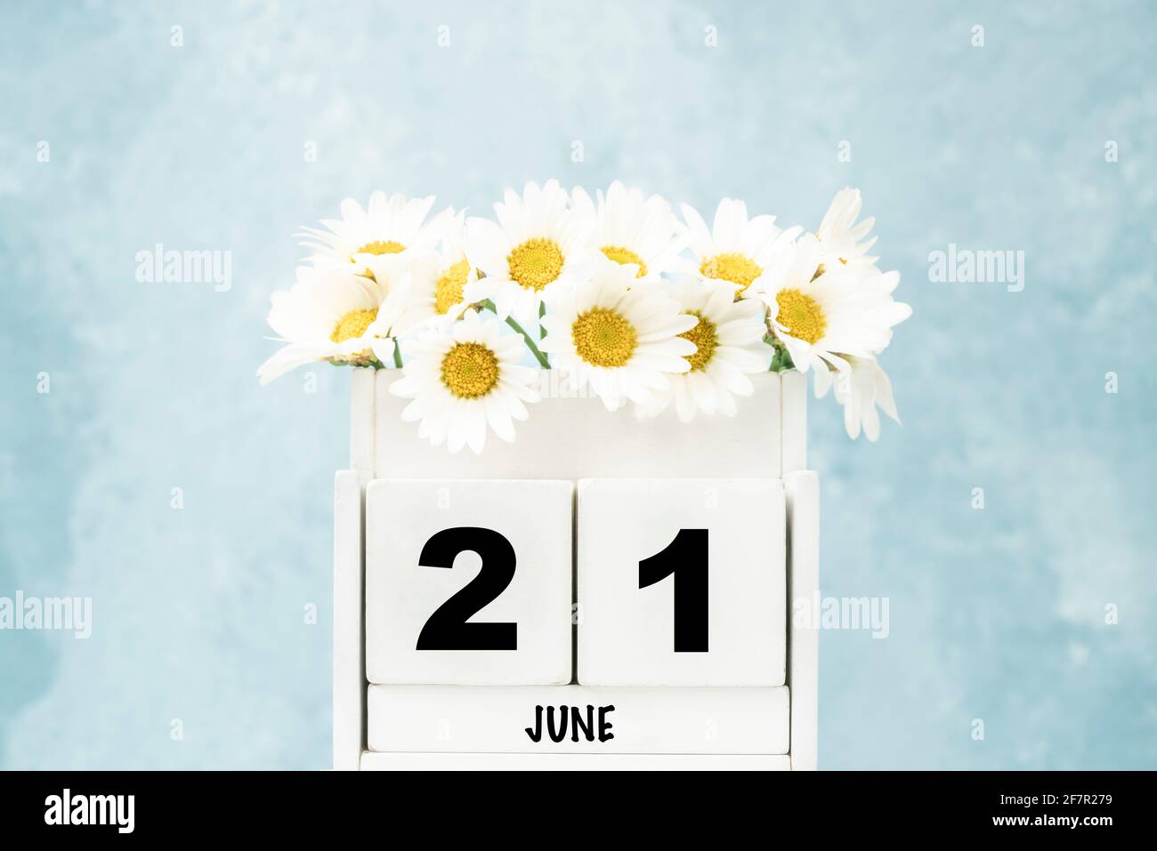 White cube calendar for June with daisy flowers over blue background ...