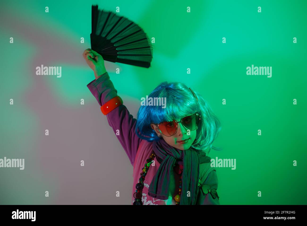 Little girl posing with a fan for a photo shoot Stock Photo - Alamy