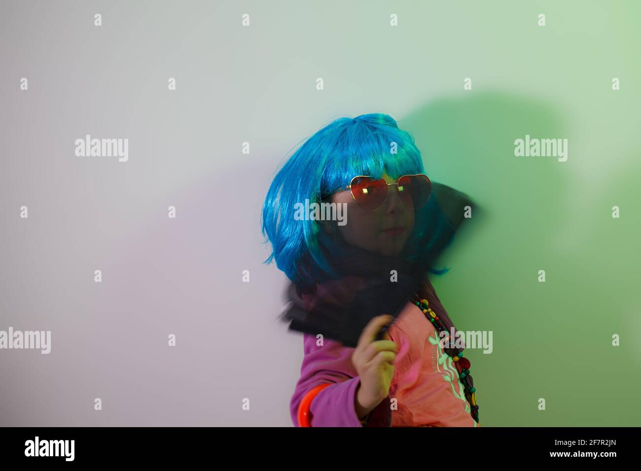 Little girl posing with a fan for a photo shoot Stock Photo - Alamy