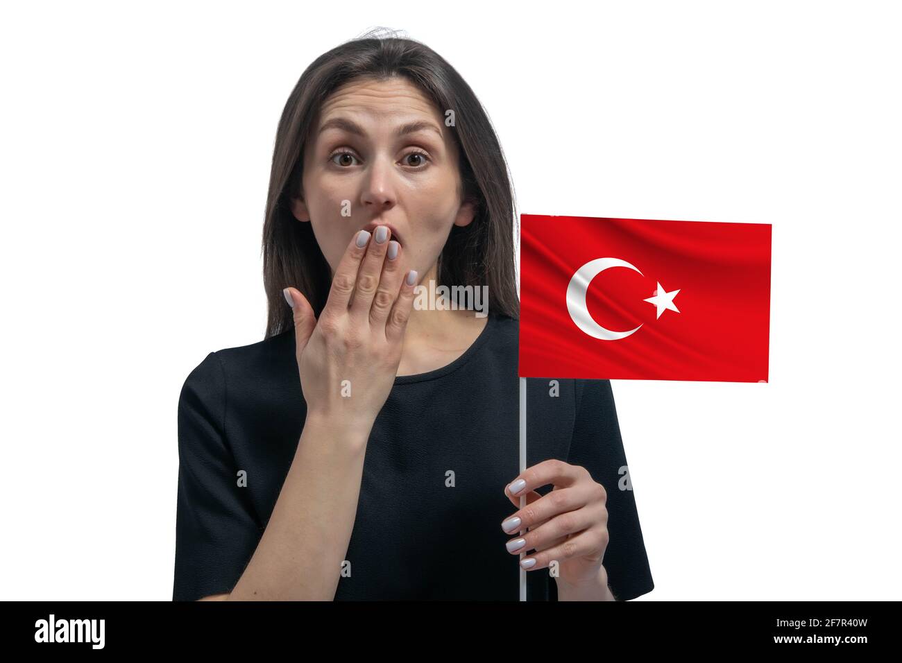 Happy young white woman holding flag of Turkey and covers her mouth ...