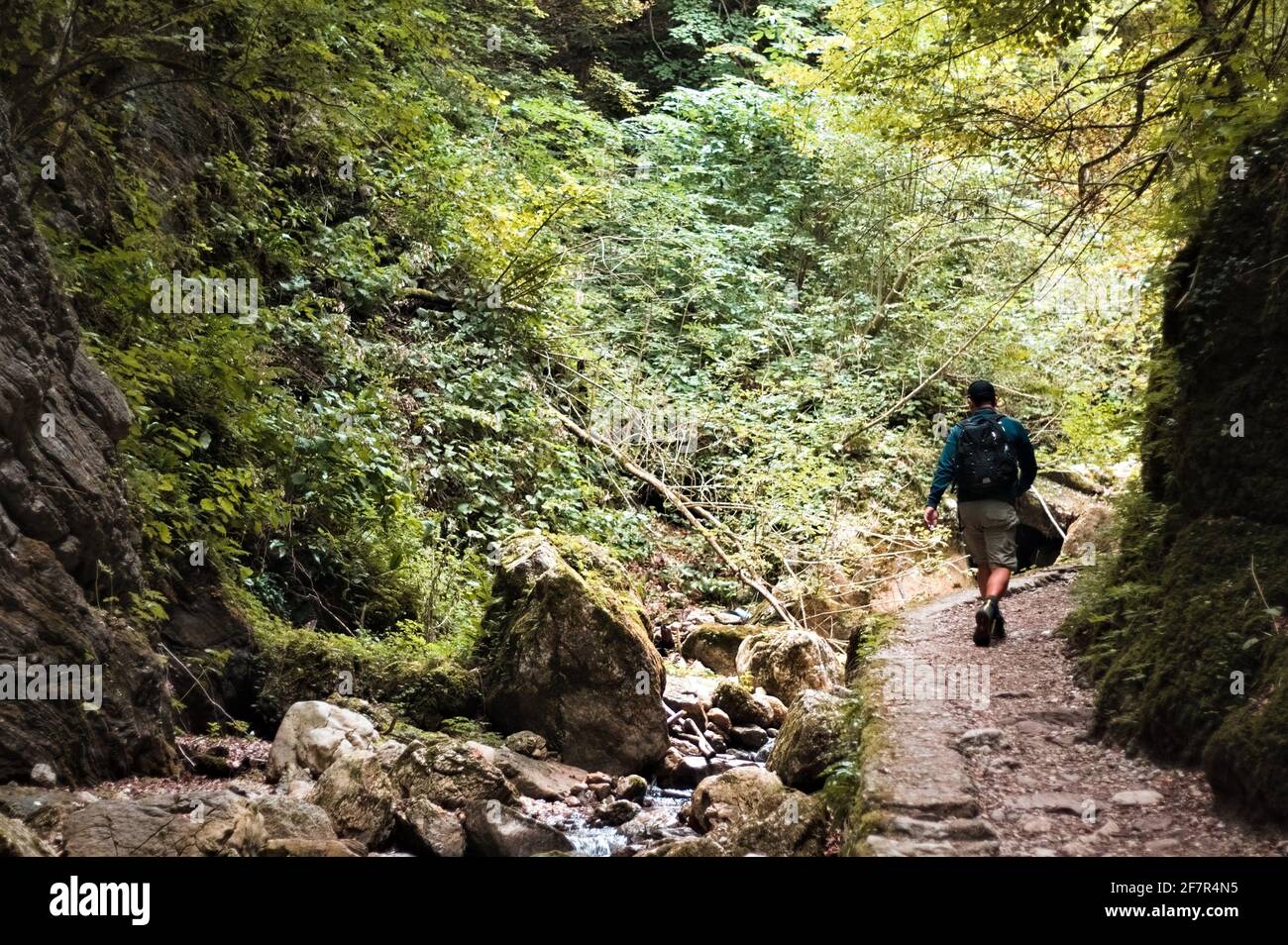 A man is walking in a gorge carved into the rock of an Italian canyon ...