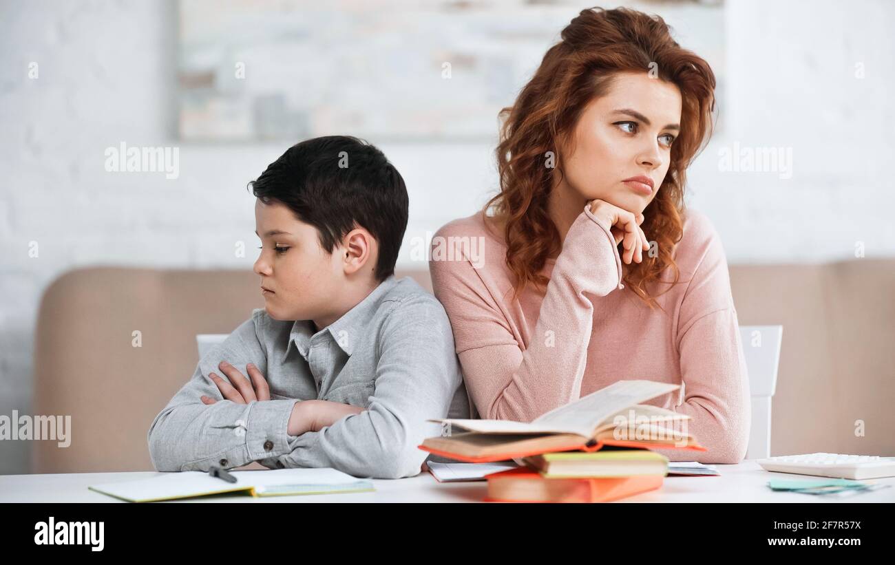 Sad woman sitting near son during home education Stock Photo - Alamy