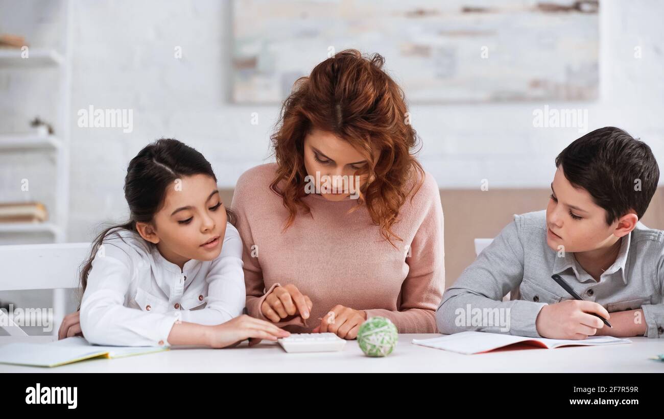 Children and mother using calculator during home education Stock Photo ...