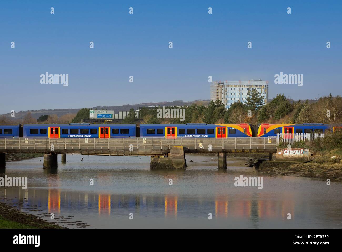 A Stagecoach train passing a bridge and reflecting on the water Stock ...