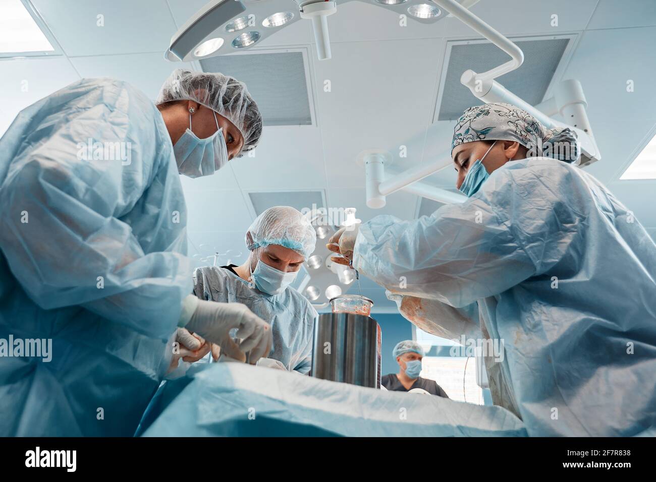 cosmetic liposuction surgery in actual operating room setting showing ...