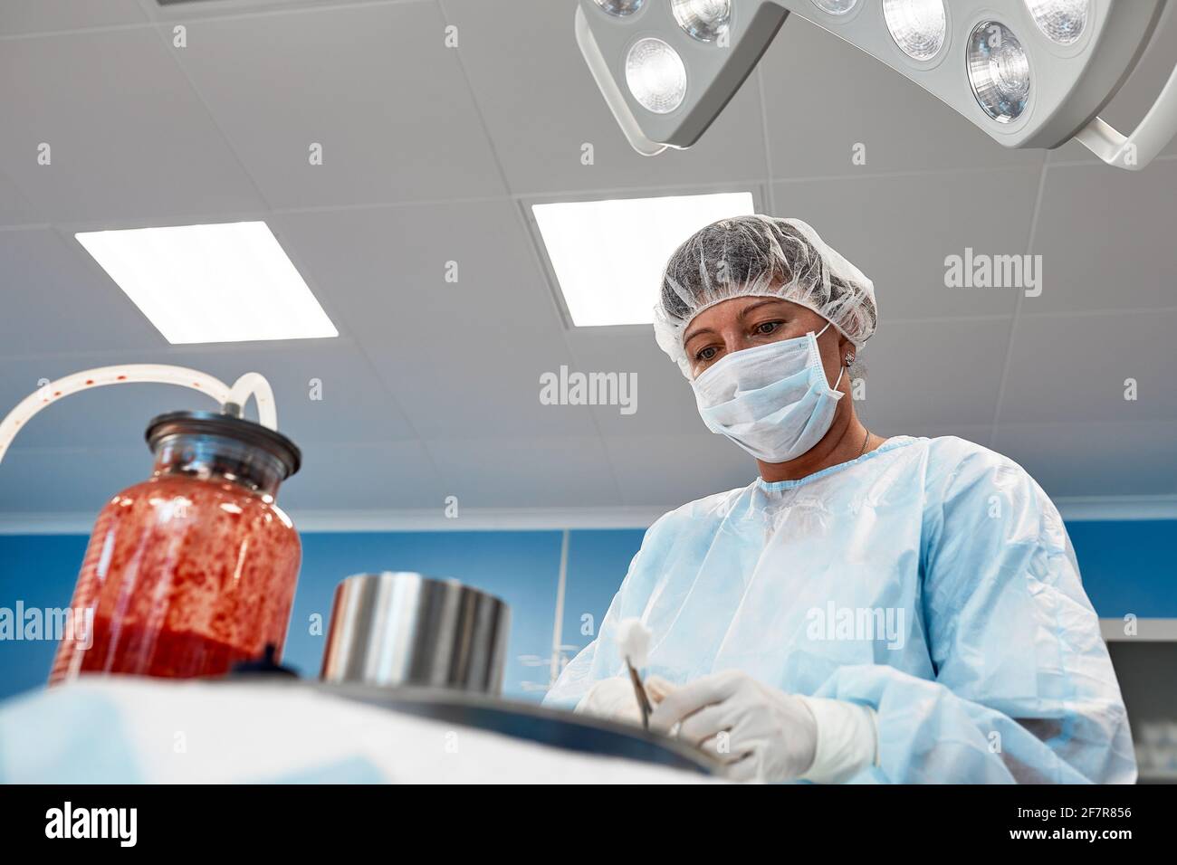 cosmetic liposuction surgery in actual operating room setting showing ...