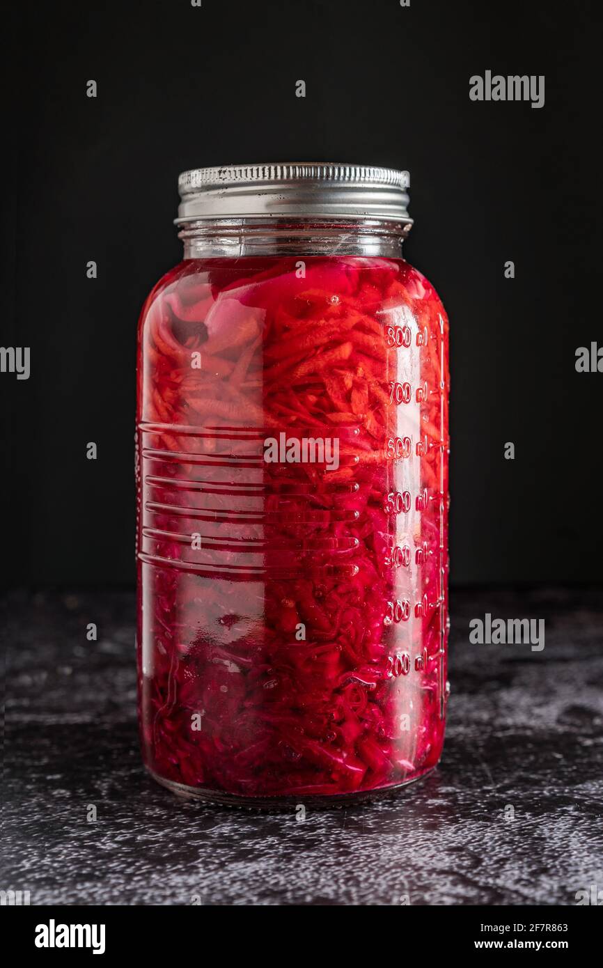 Dark moody food photography of a jar with homemade fermented red ...