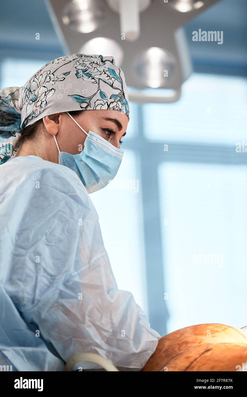 cosmetic liposuction surgery in actual operating room setting showing ...