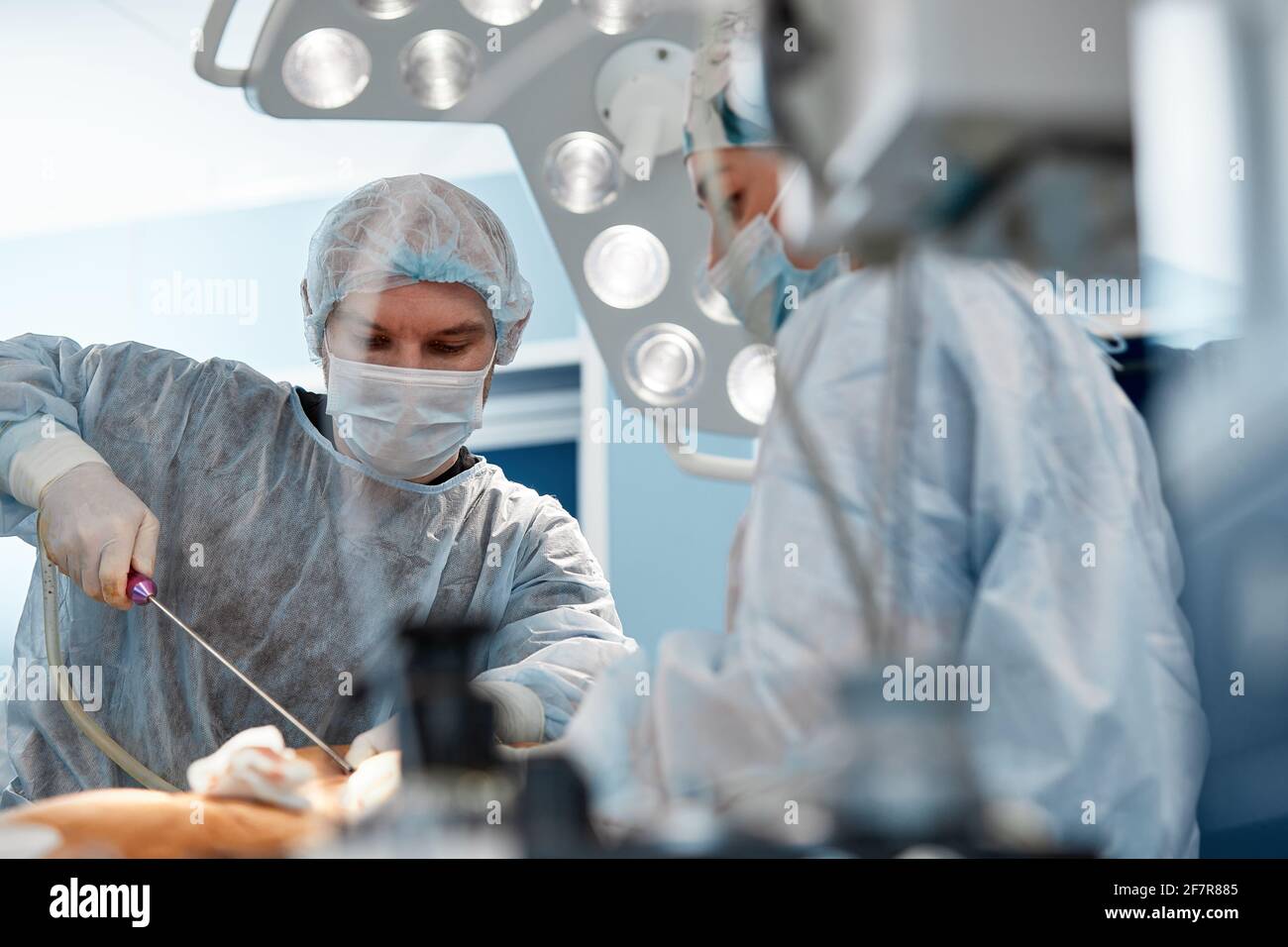 cosmetic liposuction surgery in actual operating room setting showing ...