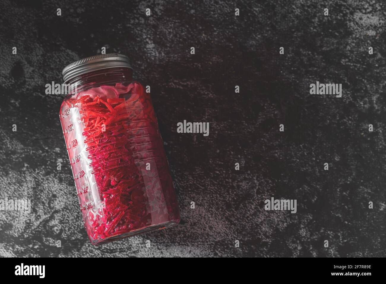 Dark moody food photography of a jar with homemade fermented red ...