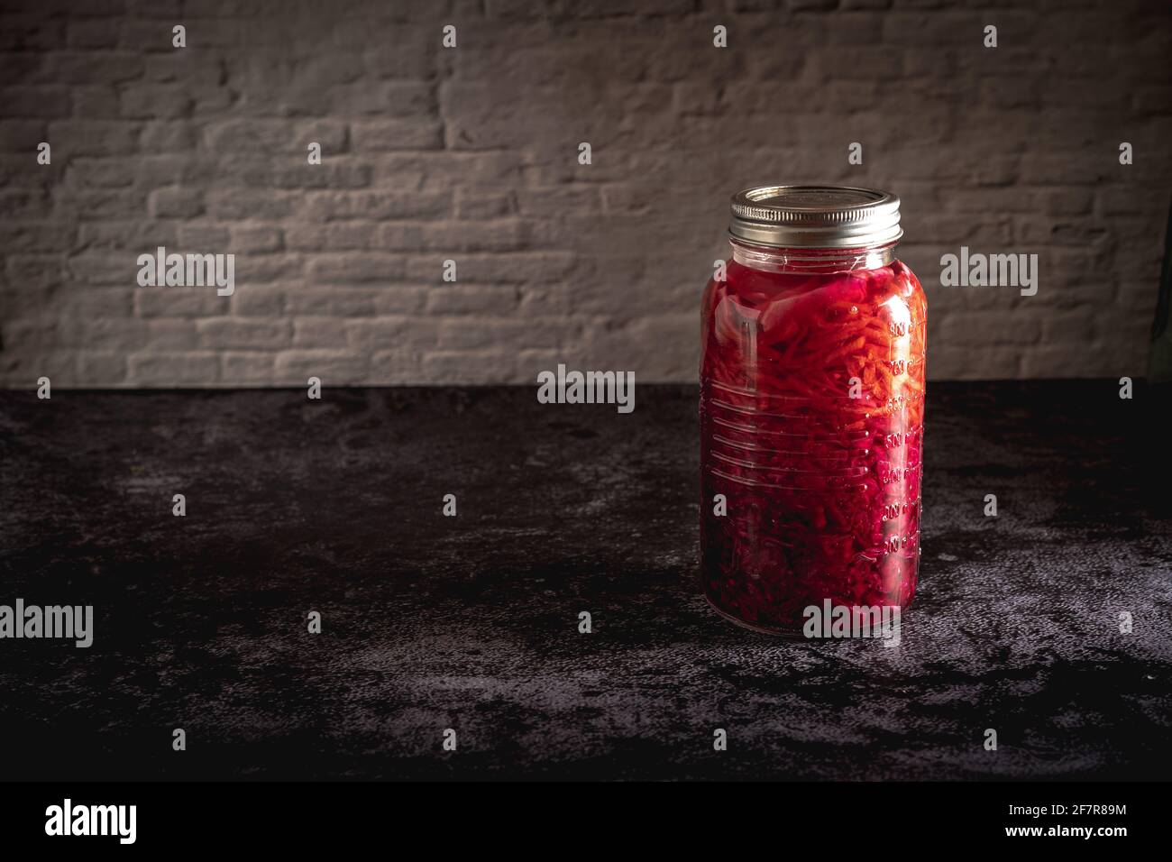 Dark moody food photography of a jar with homemade fermented red ...