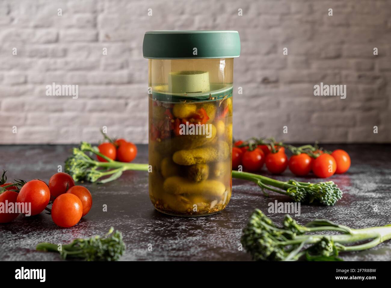 Retro food photography of a press jar with homemade fermented pickles ...