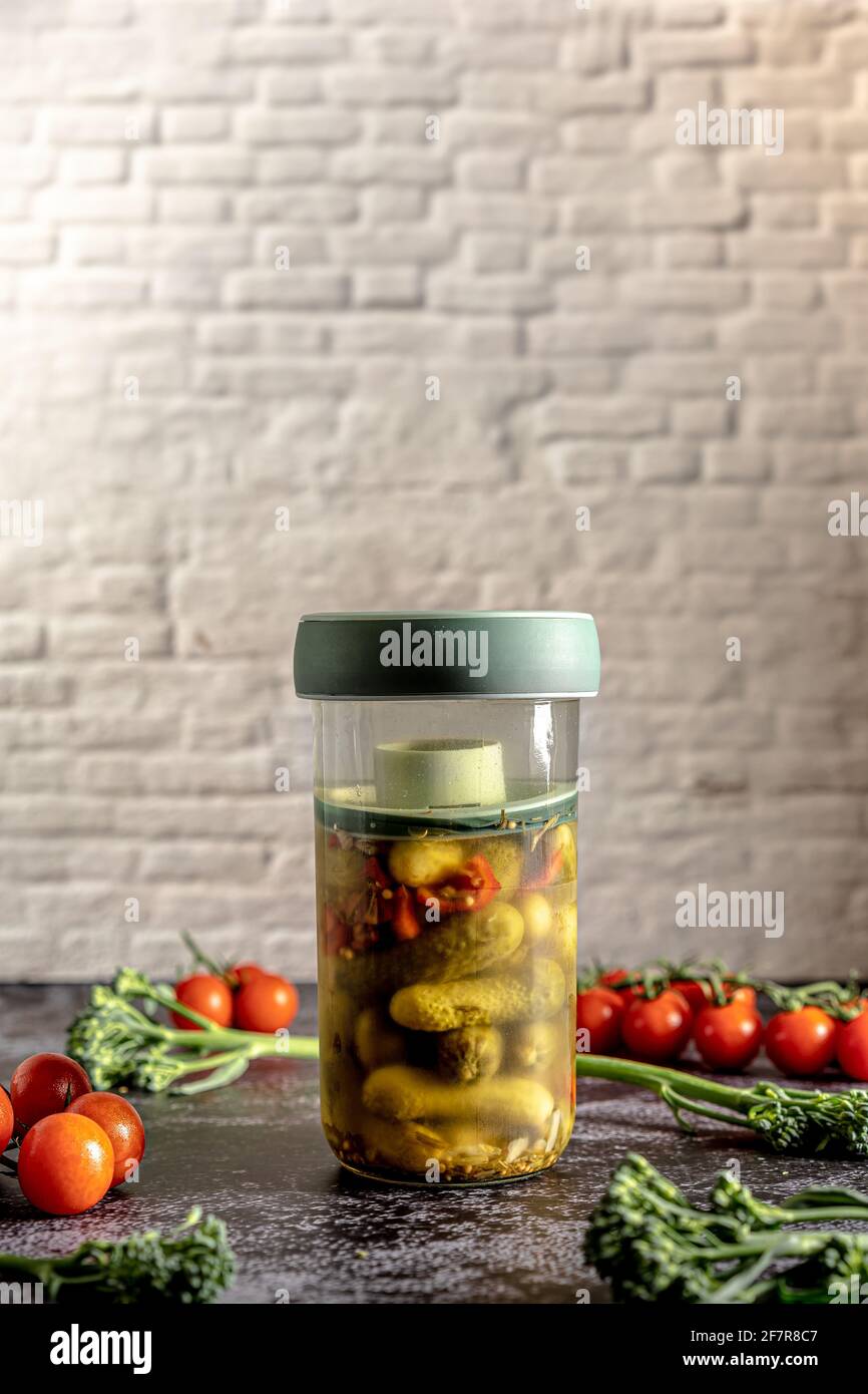 Retro food photography of a press jar with homemade fermented pickles ...