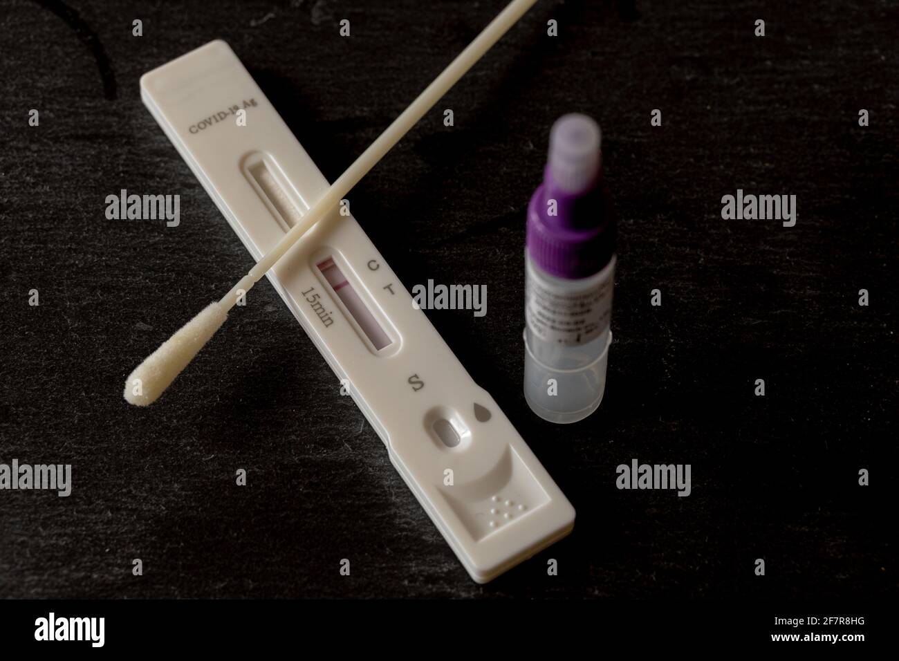 Negative Corona self-test with cotton swab in front of neutral dark ...