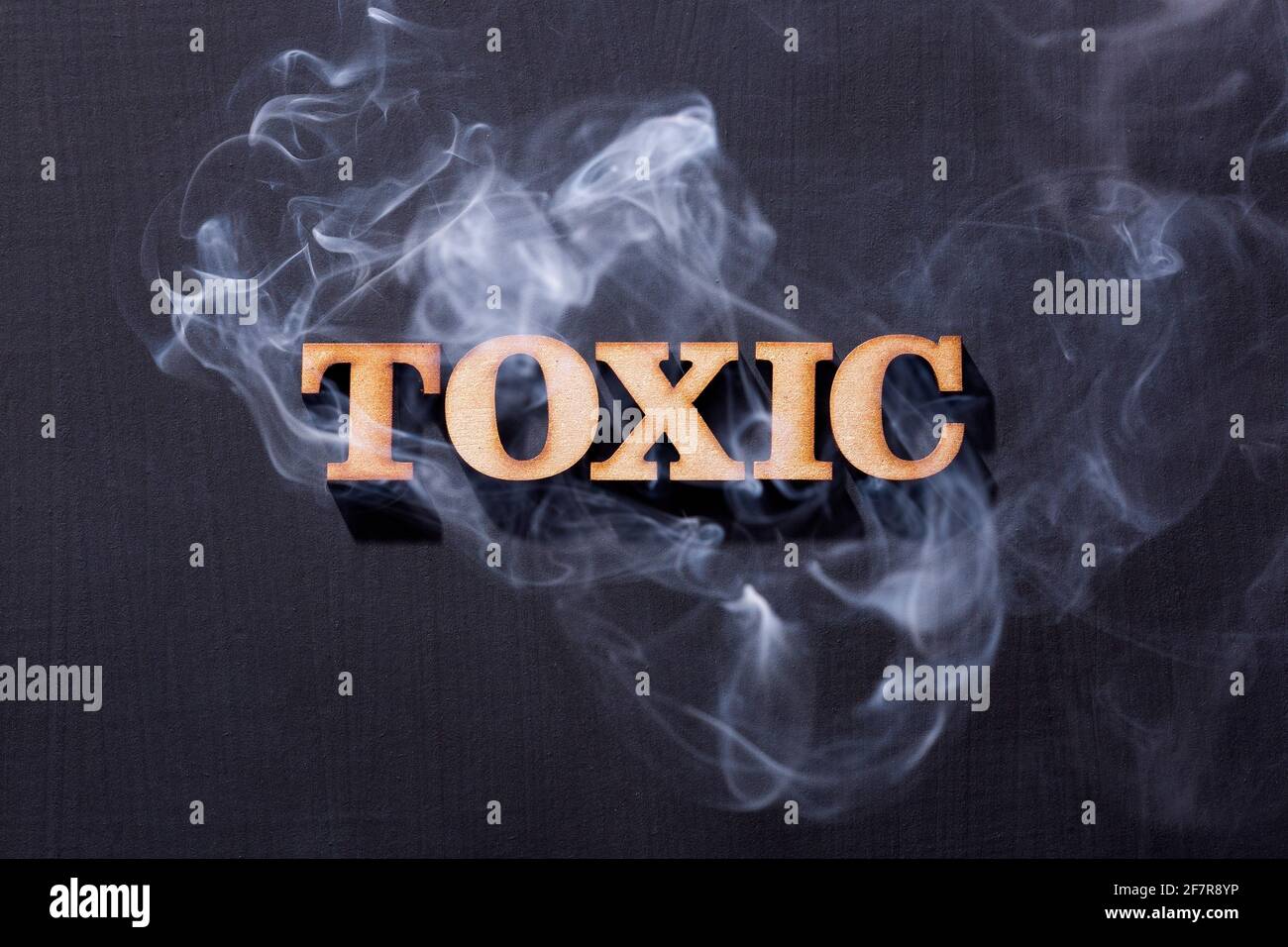 Toxic word in wooden letters with smoke Stock Photo - Alamy