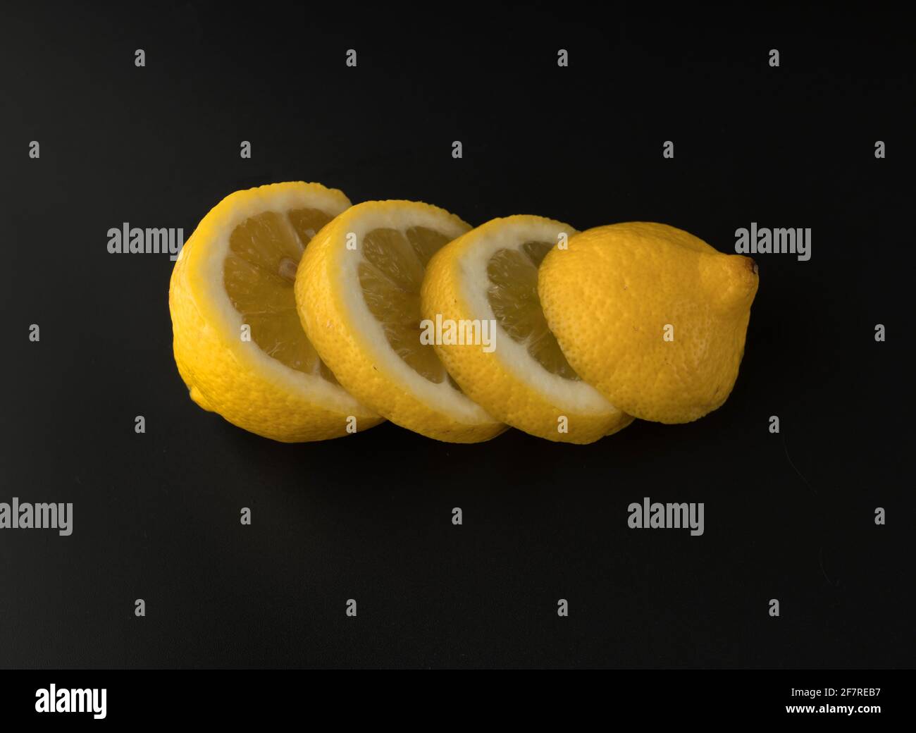 Lemon sliced in round slices, on black background isolated Stock Photo ...