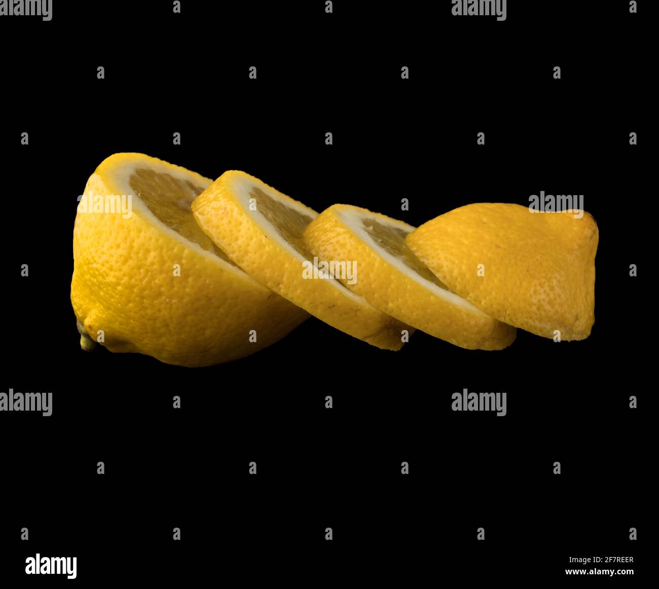 Lemon cut into round slices and slices arranged, in a row on black ...