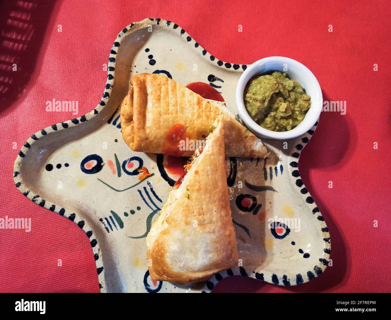 Tex mex spicy calzone with guacamole sauce, Mexican cuisine on a ...