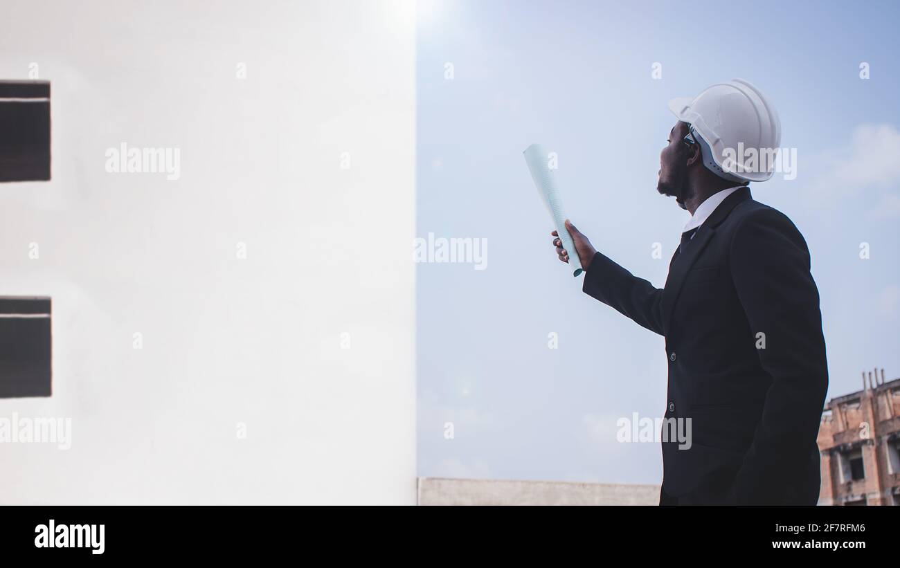 African engineer manager architect looking at construction project ...