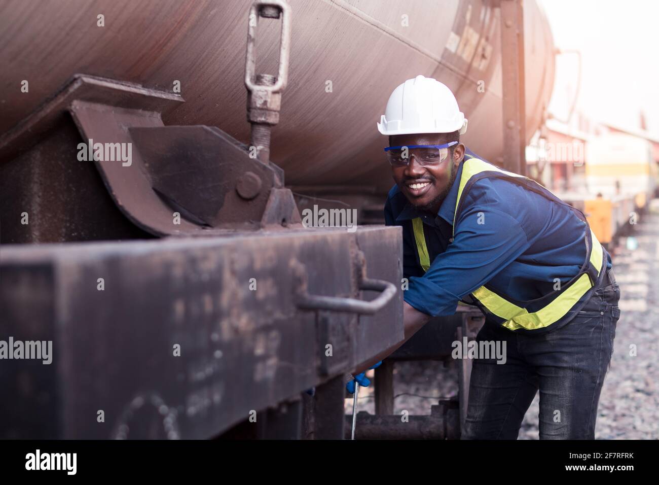 African machine engineer technician wearing a helmet, groves and safety ...