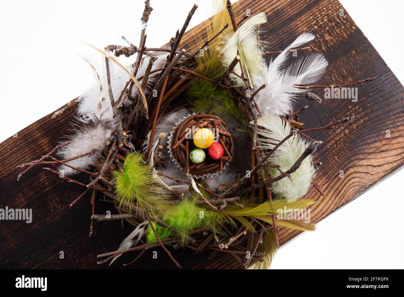 Easter themed nest decoration with tree sticks and colorful feathers ...