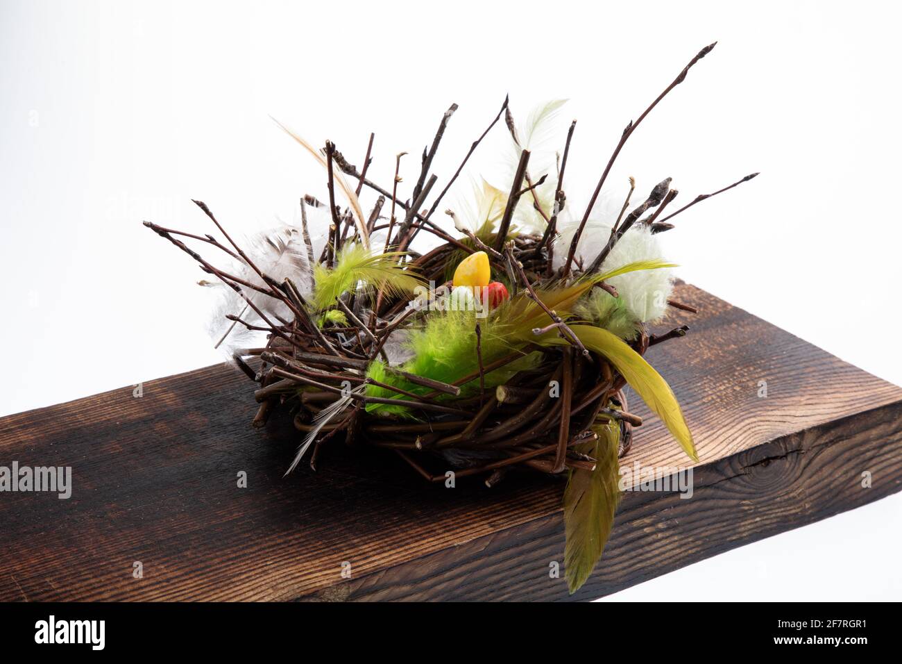 Easter themed nest decoration with tree sticks and colorful feathers ...