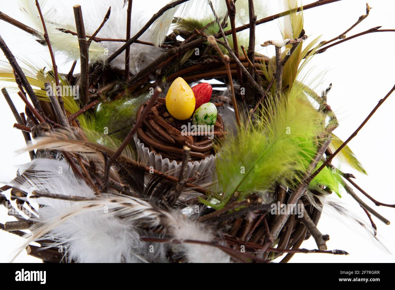 Easter themed nest decoration with tree sticks and colorful feathers ...