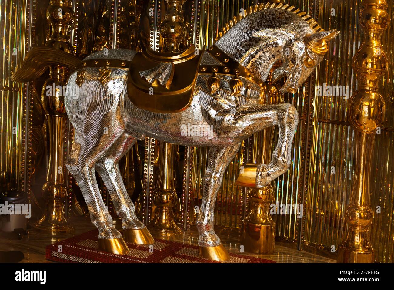 Horizontal close-up view of a golden carousel horse used for decoration ...