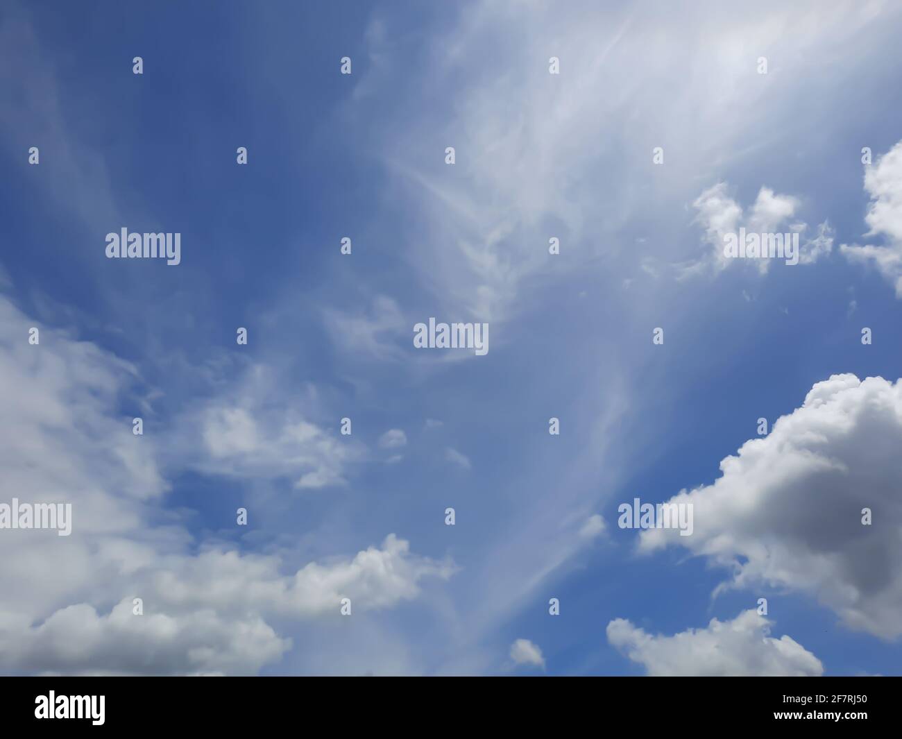 Cloudscape background with white distinctive cloud shapes and light ...