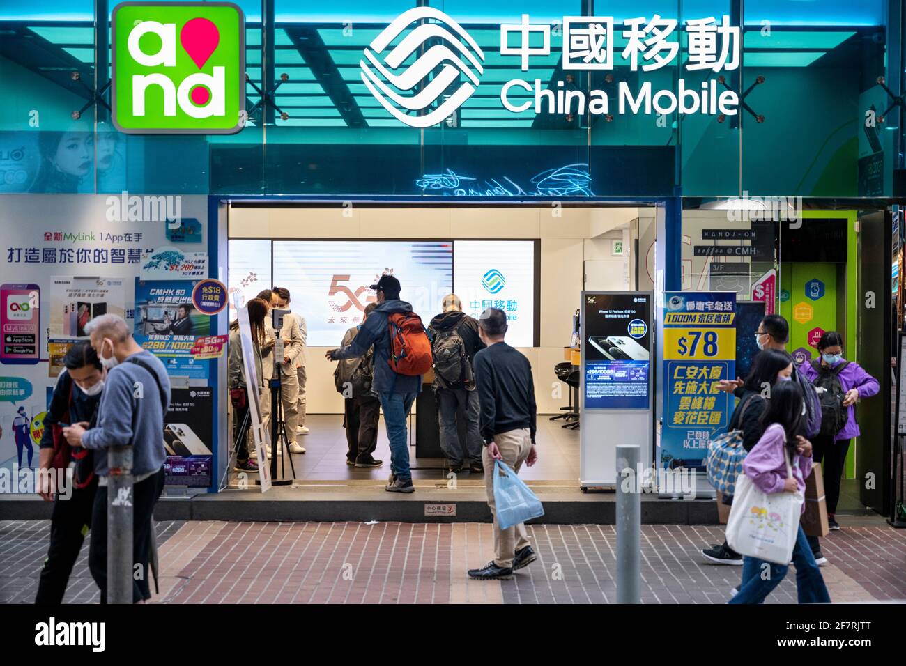 Pedestrians walk past Chinese state-owned telecommunication corporation ...