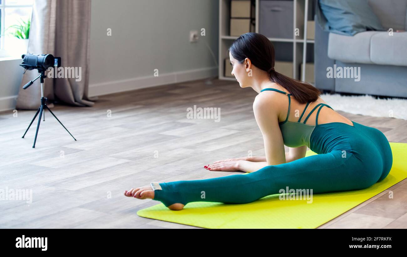Beautiful coach sitting on a floor and recording a video tutorial for ...