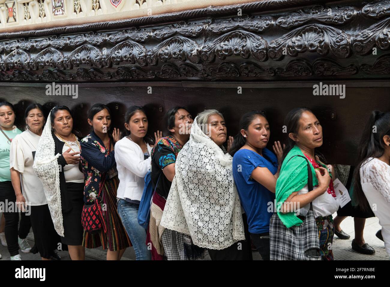 Women carry an elaborate wooden float (anda) during the Semana Santa ...