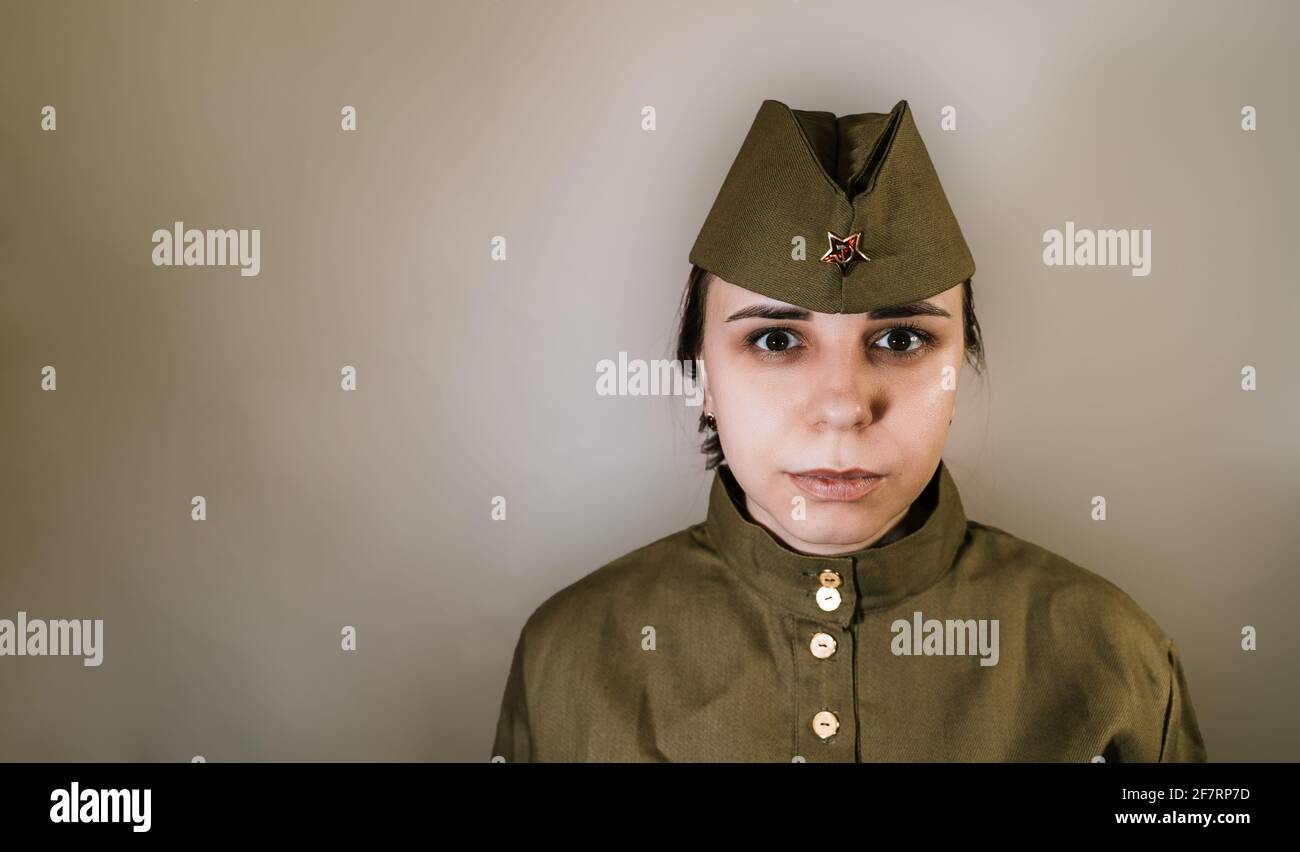 Portrait of young woman in uniform on background of gray wall. Female ...