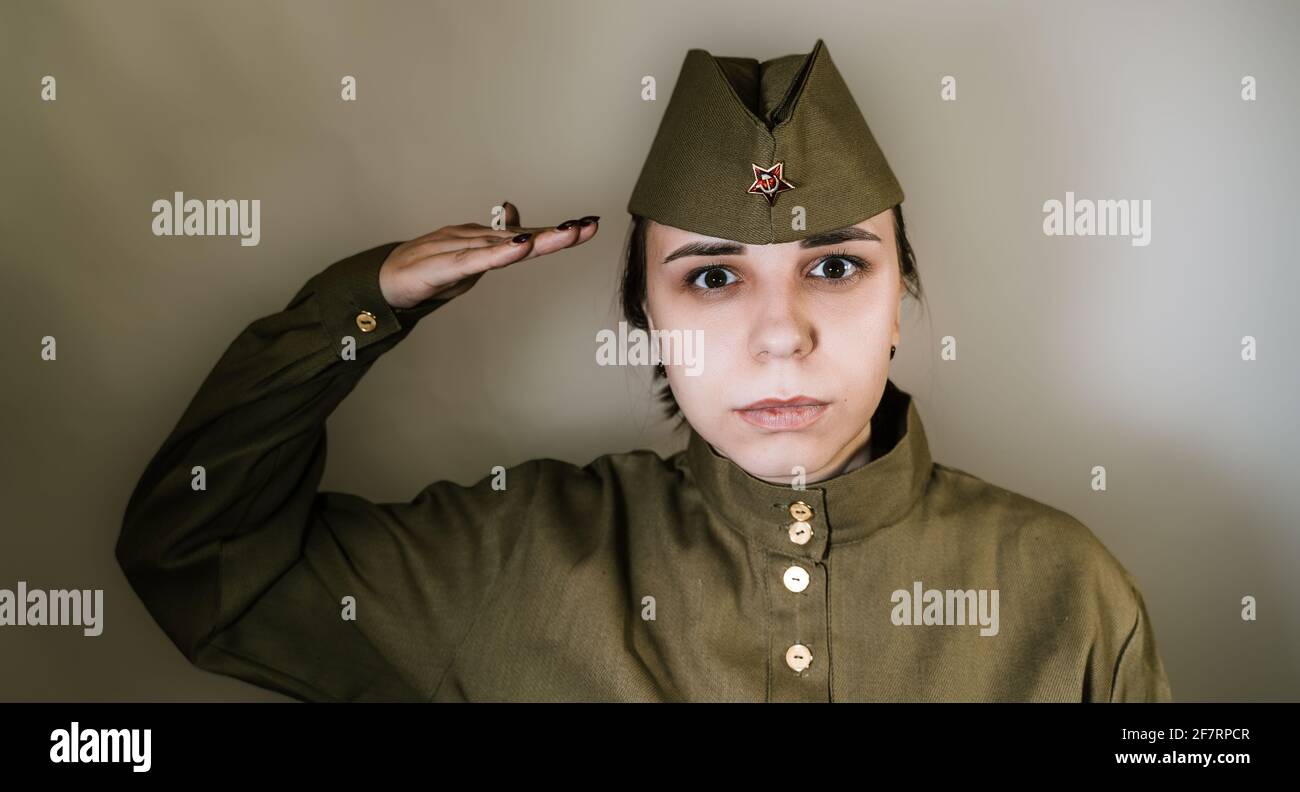 Portrait of young woman in uniform on background of gray wall. Female ...