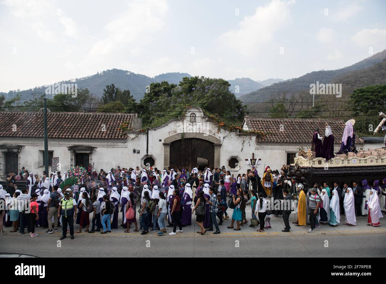 Well-dressed men in suits and women in traditional attire participate ...