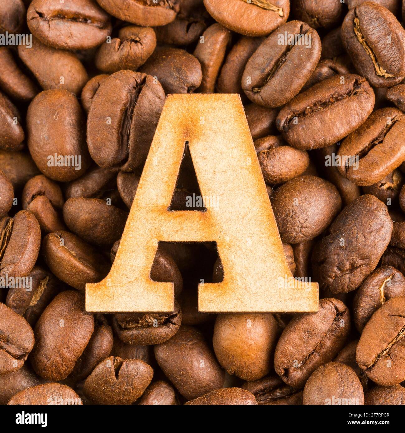 A, Letter of the alphabet on wood- background of coffee beans. Coffea ...