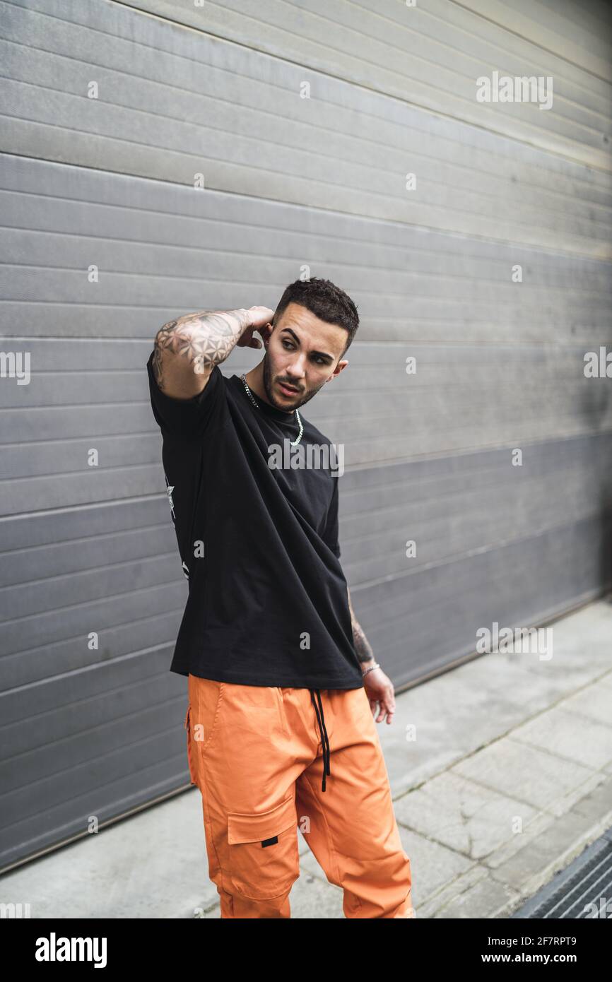 Spanish stylish man with tattoos posing in the street Stock Photo - Alamy