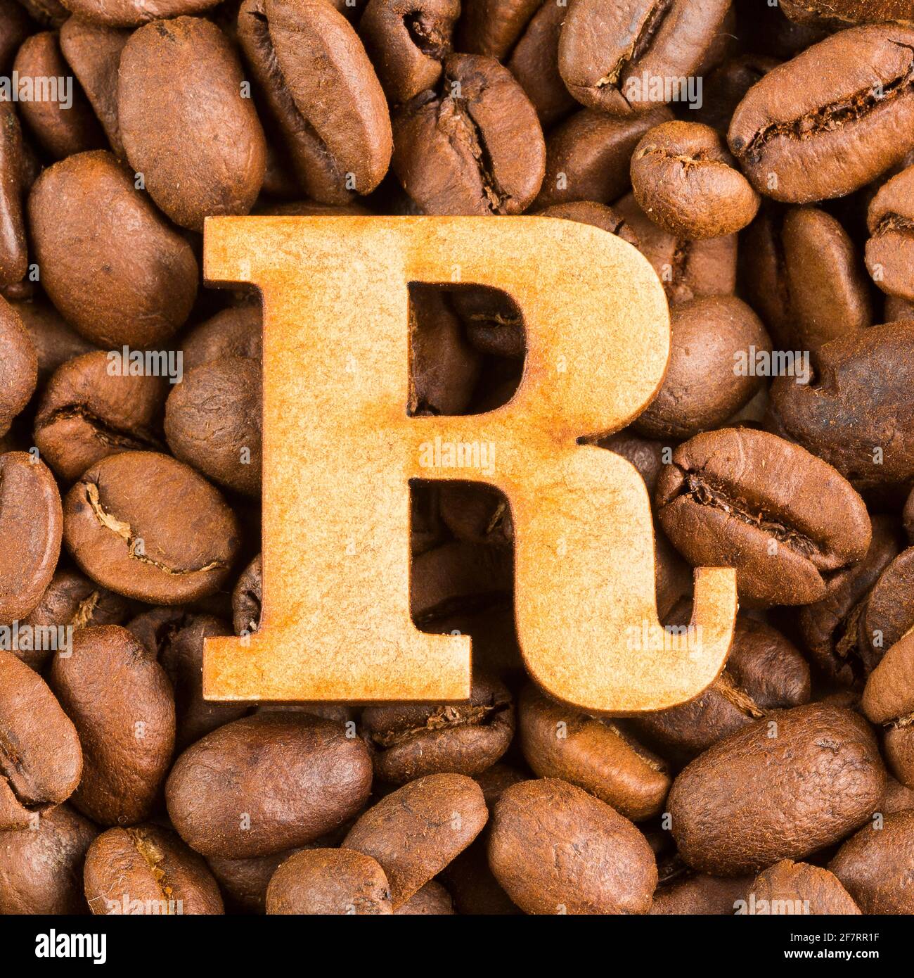 R, Letter of the alphabet on wood- background of coffee beans. Coffea ...