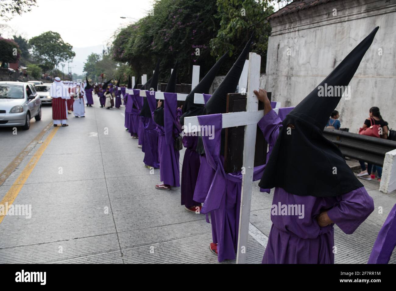 Hooded penitents carry crosses during Semana Santa procession in ...
