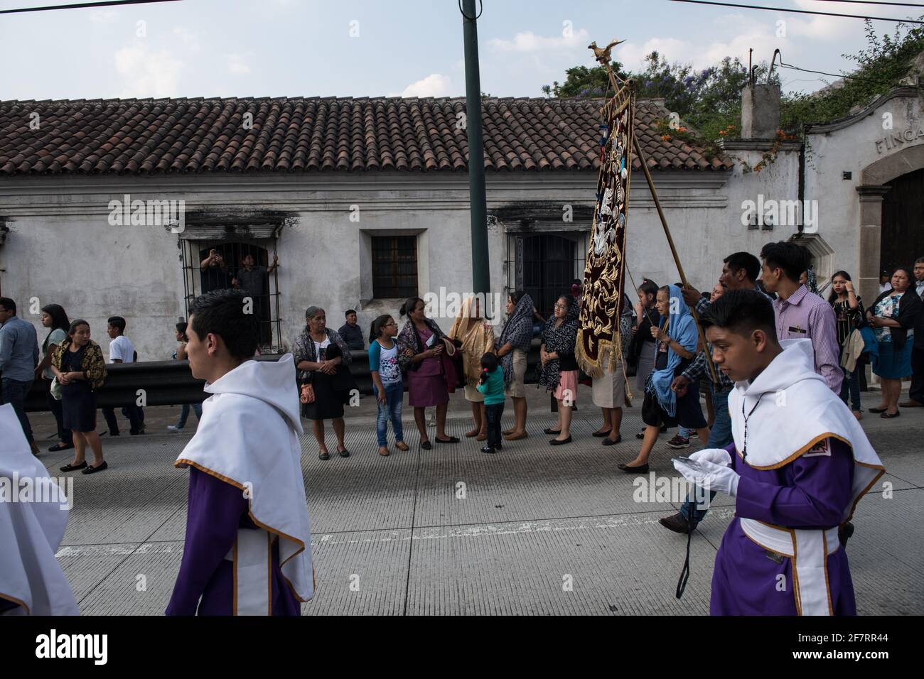 Hooded penitents carry crosses during Semana Santa procession in ...