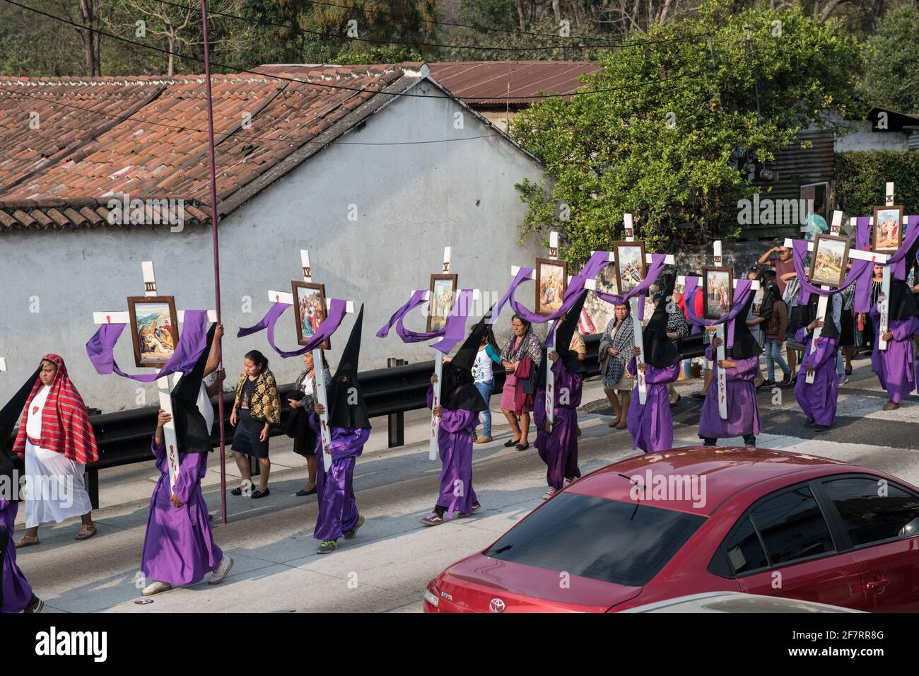 Hooded penitents carry crosses during Semana Santa procession in ...