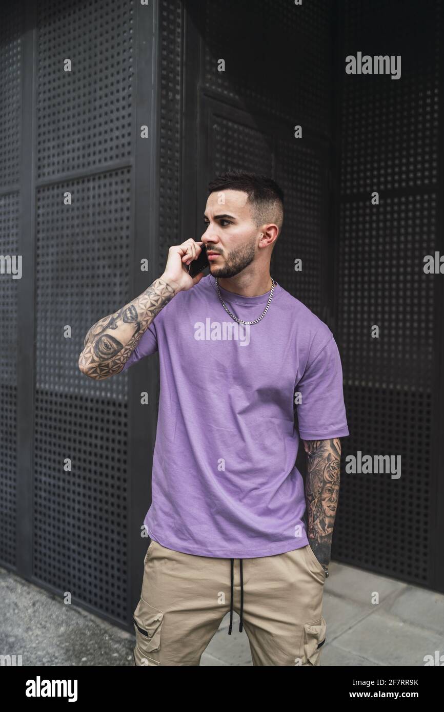 Spanish young man with tattoos talking on phone Stock Photo - Alamy