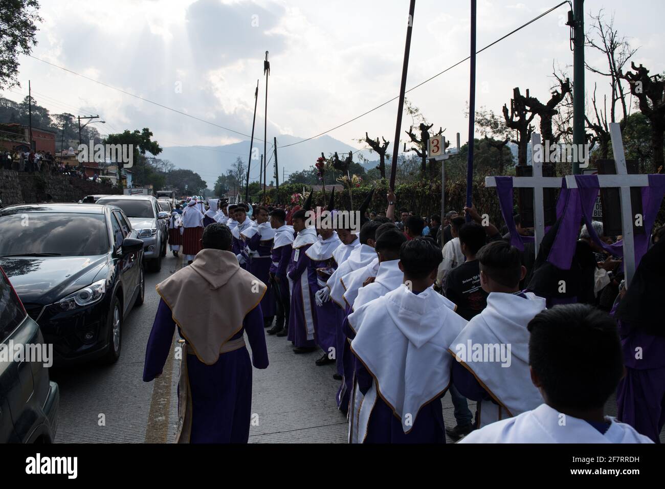 Hooded penitents carry crosses during Semana Santa procession in ...