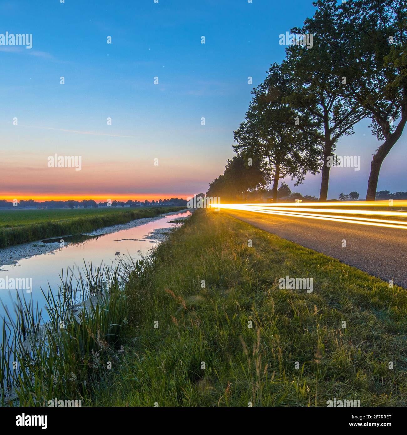 Netherlands open polder landscape with canal and traffic lights on road ...