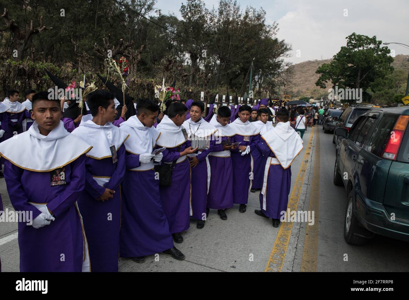 Cucuruchos in purple robes process solemnly through the streets of ...