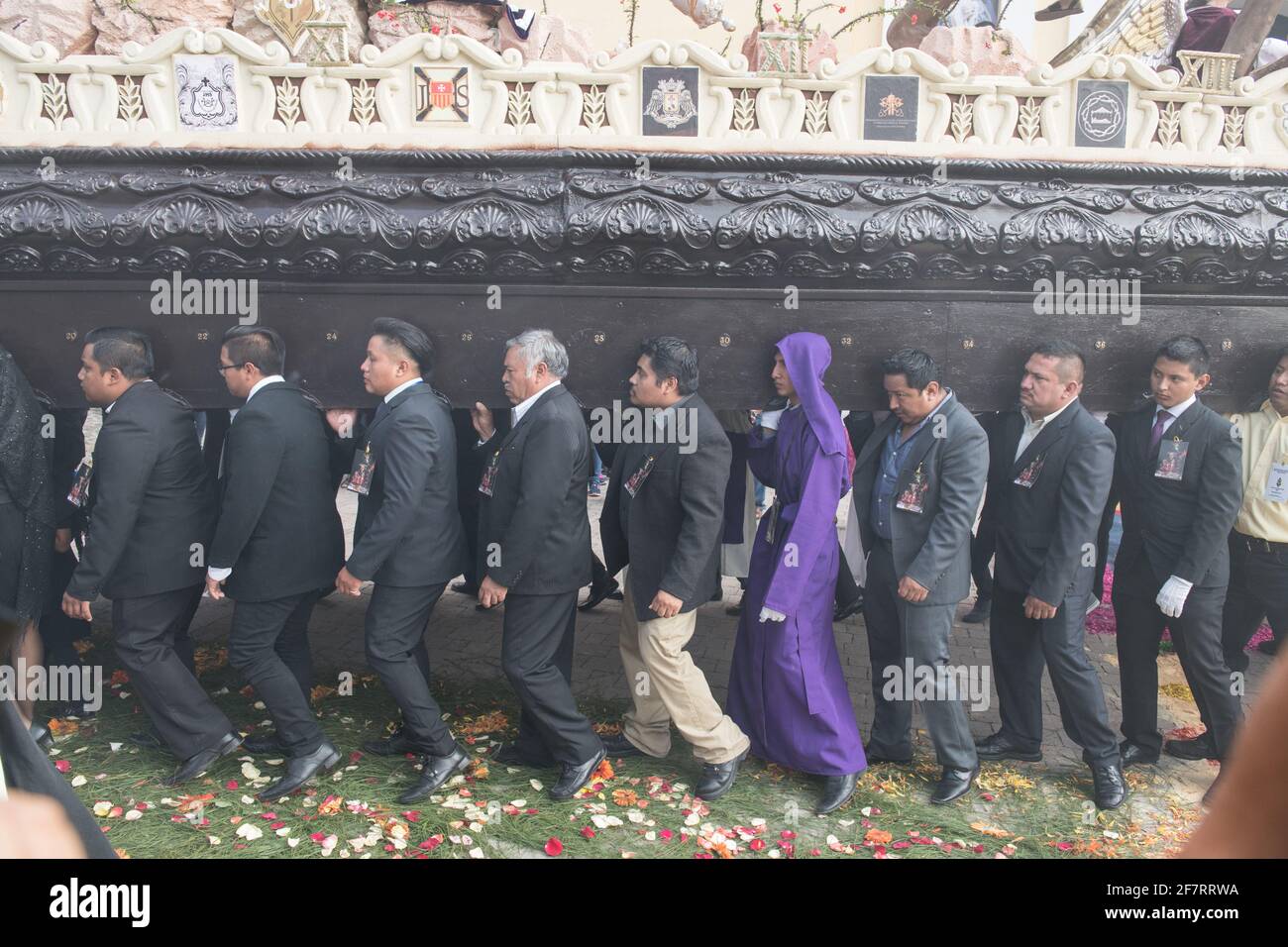 Well-dressed men in suits and women in traditional attire participate ...