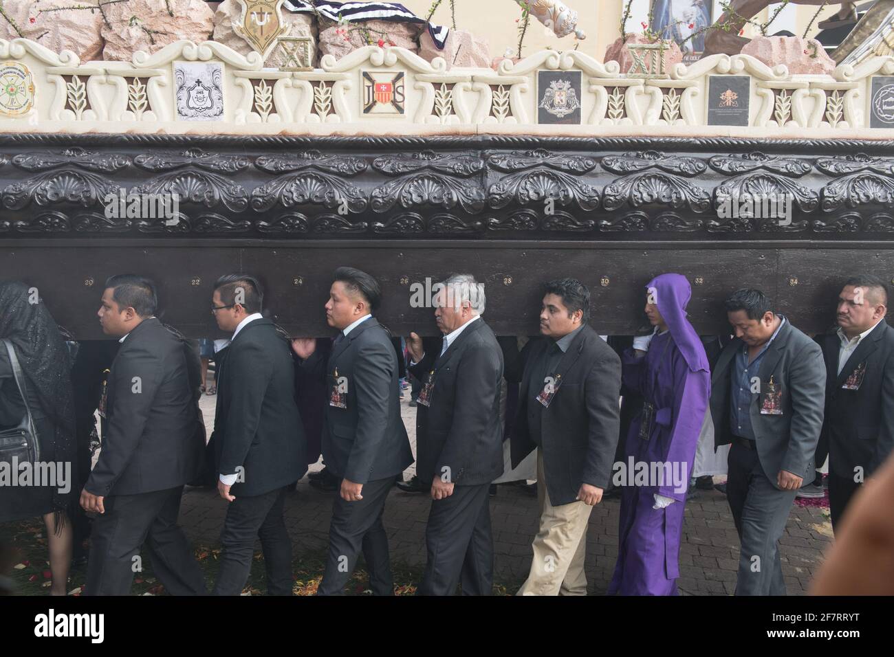 Well-dressed men in suits and women in traditional attire participate ...